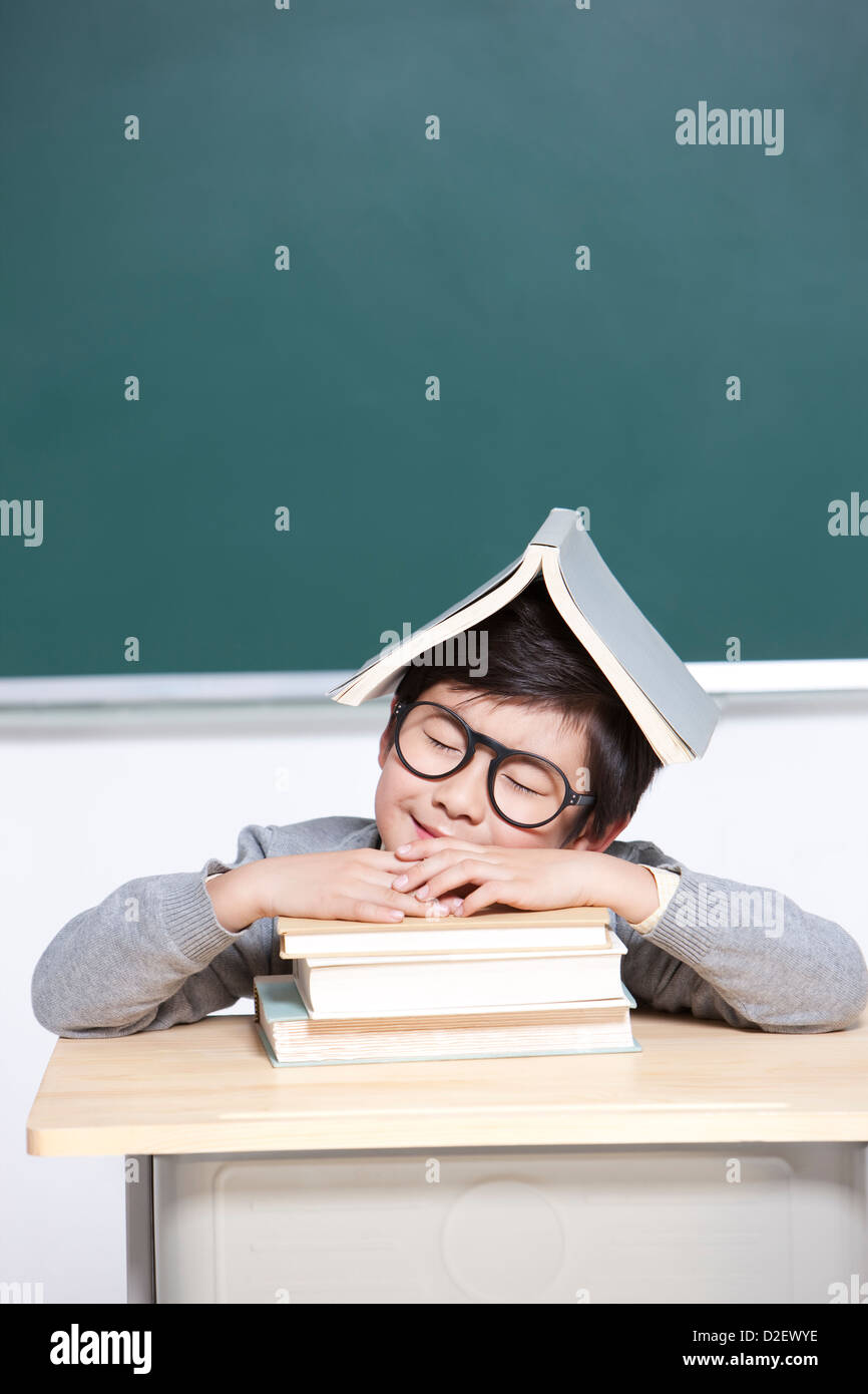 Lovely schoolboy taking a break in classroom Stock Photo - Alamy