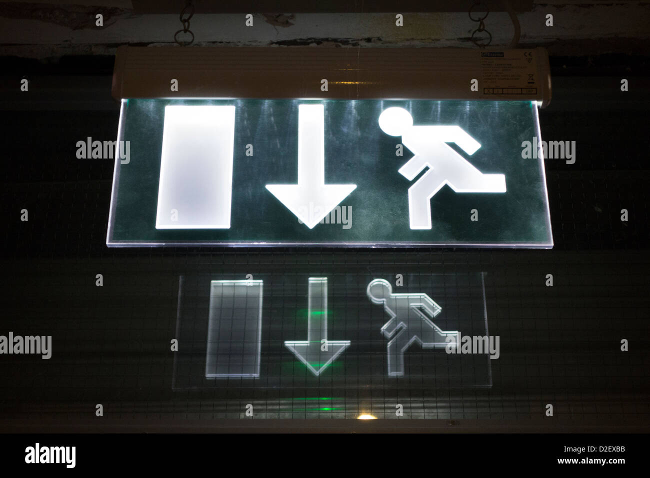 An iluminated exit sign and it's reflection in a glass door Stock Photo ...