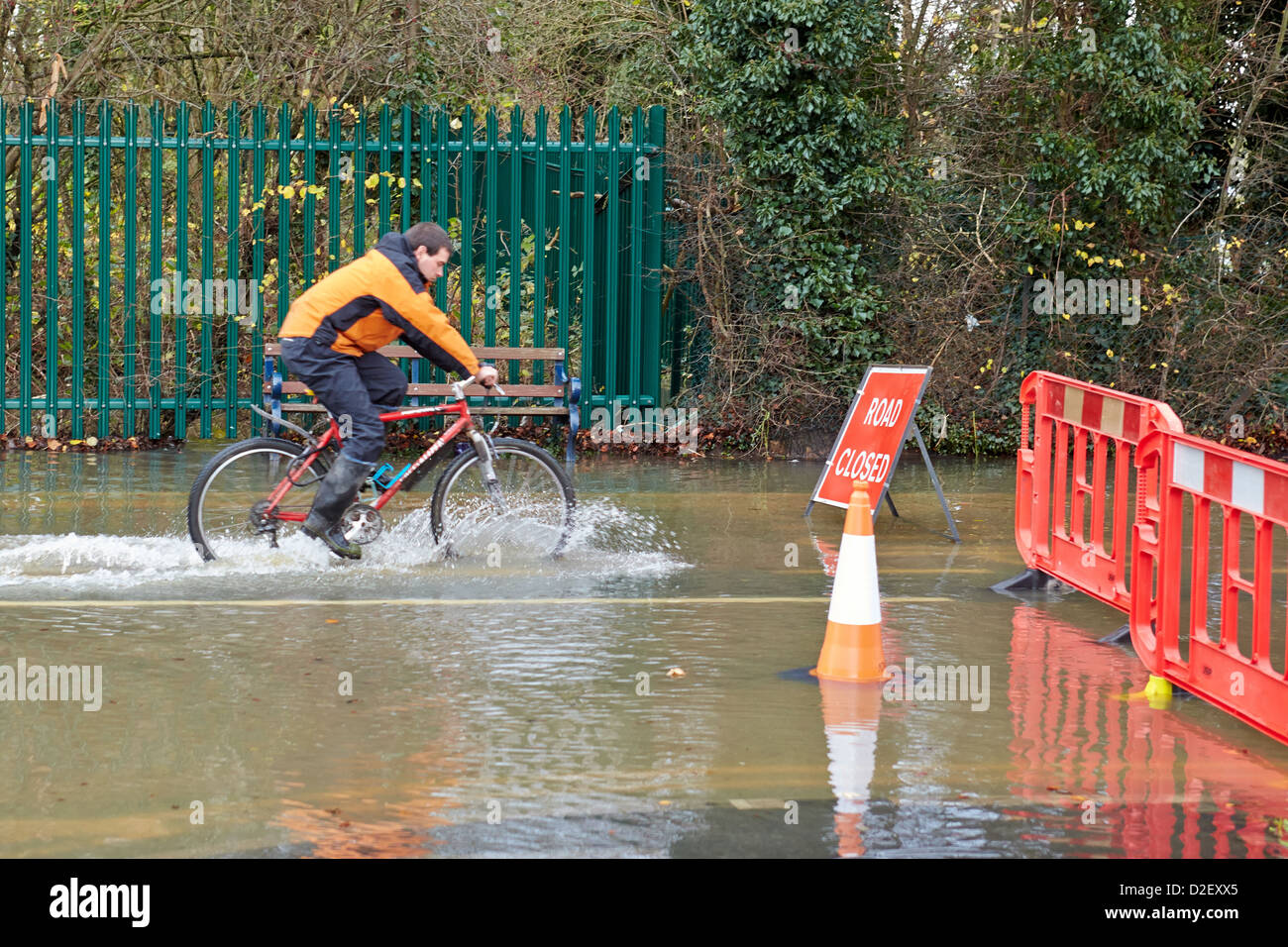 A cyclist ignores a road closed sign to cycle down a flooded street in ...