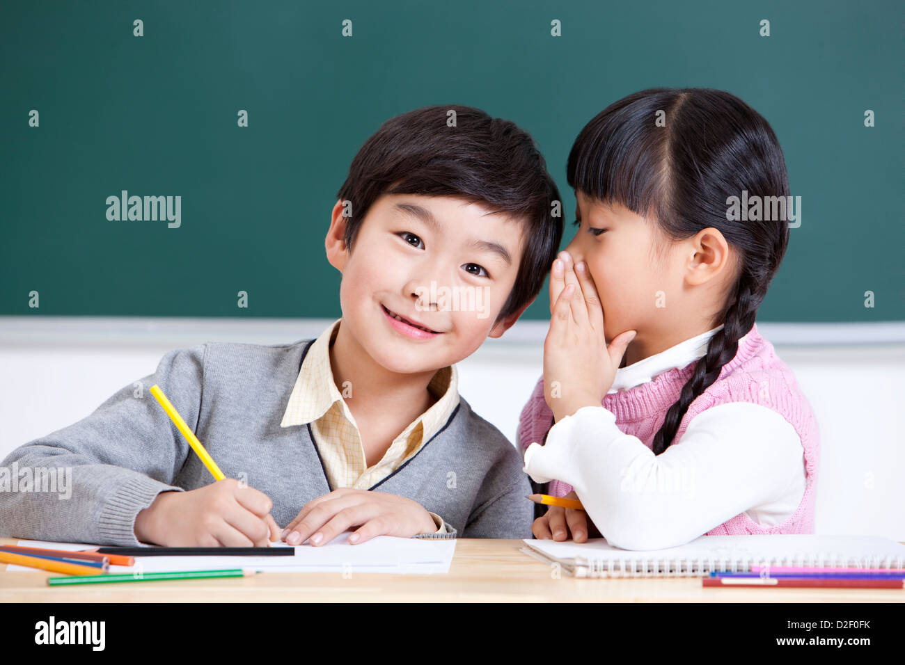 Cute schoolchildren doing homework in classroom Stock Photo - Alamy