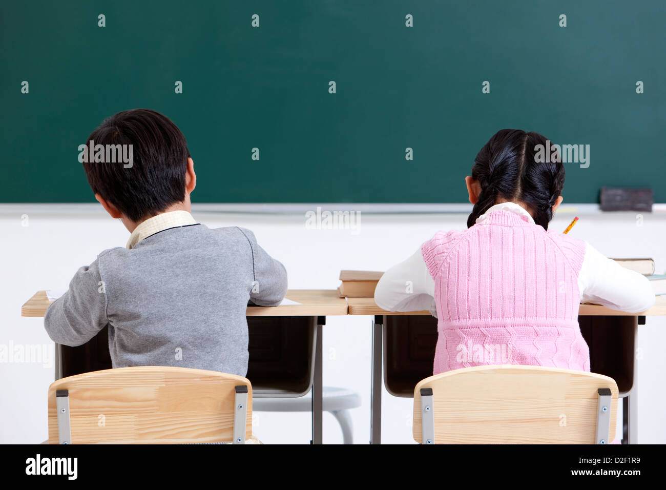 Schoolchildren raising hands in class Stock Photo - Alamy