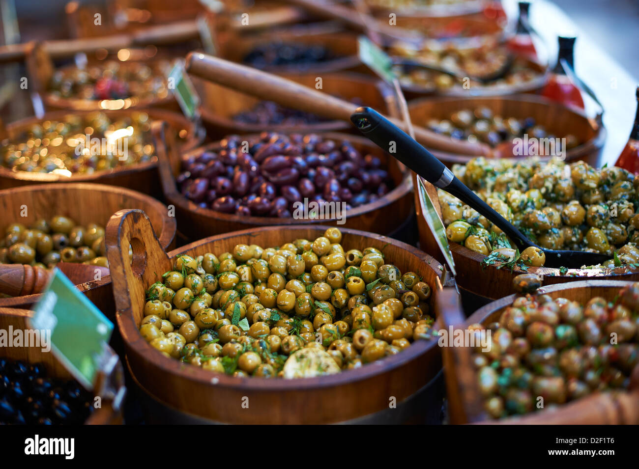 wooden barrels with varieties of olives including pitted greek kalamata ...