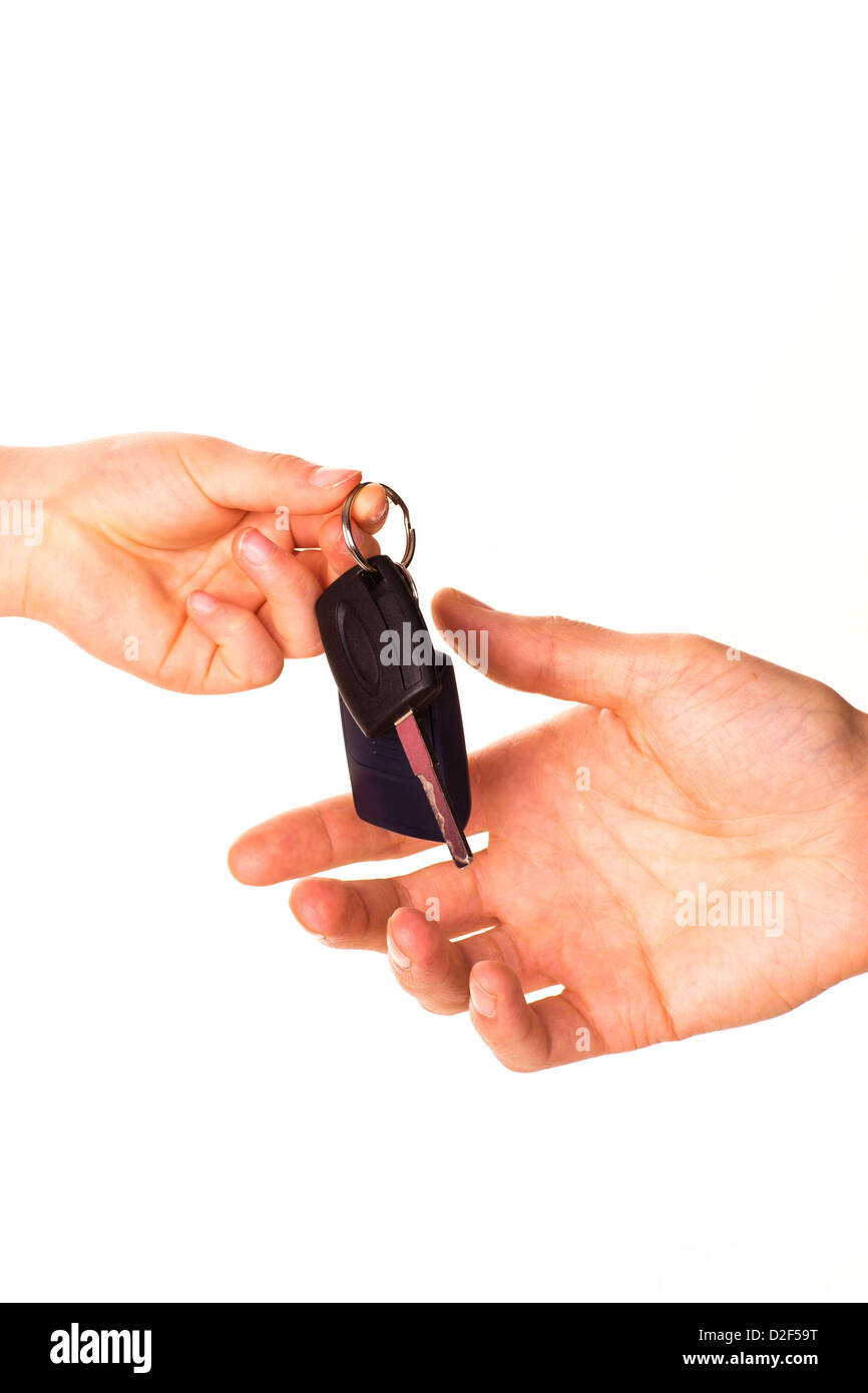 Male hand holding a car key and handing it over to another person ...