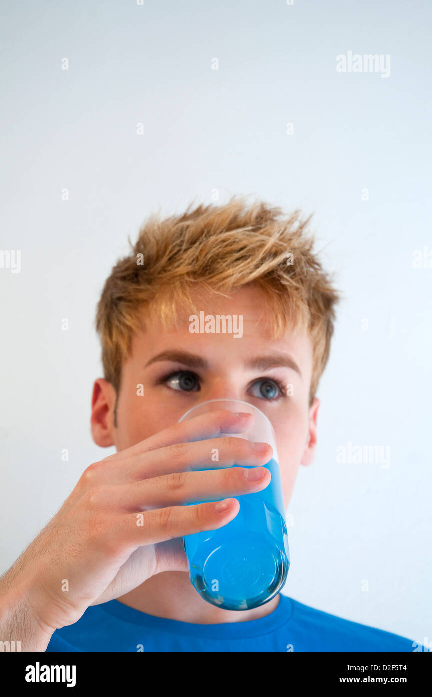 Young man drinking blue soft drink Stock Photo - Alamy