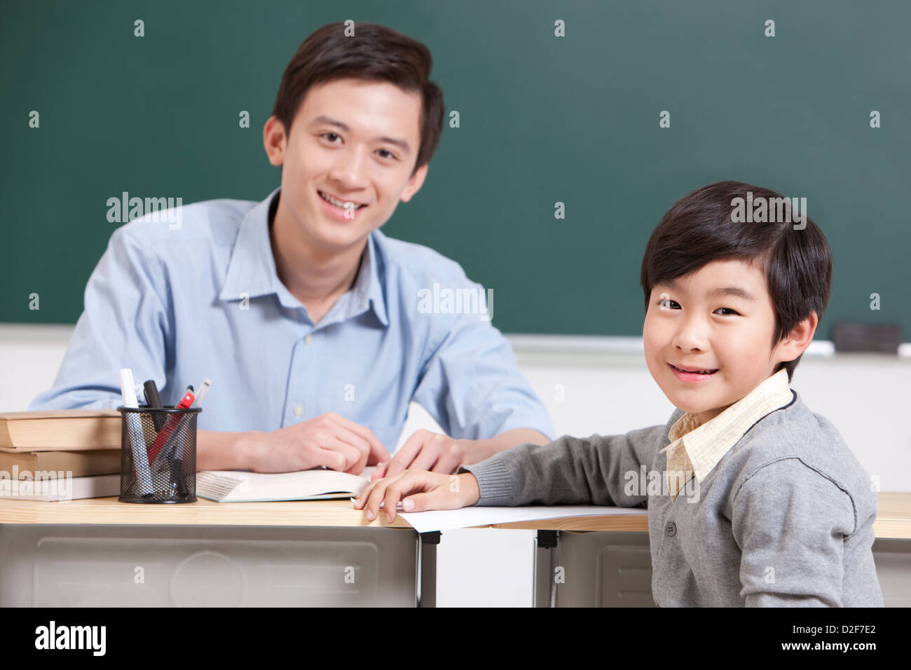 Happy schoolboy and teacher in classroom Stock Photo - Alamy