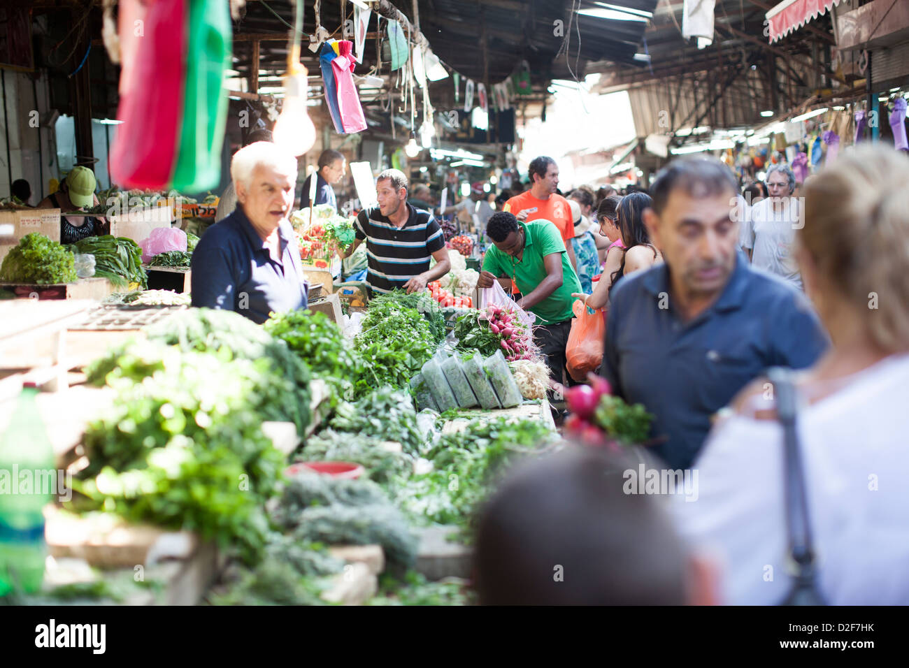Market stall owners serve customers in the main market in Tel Aviv ...