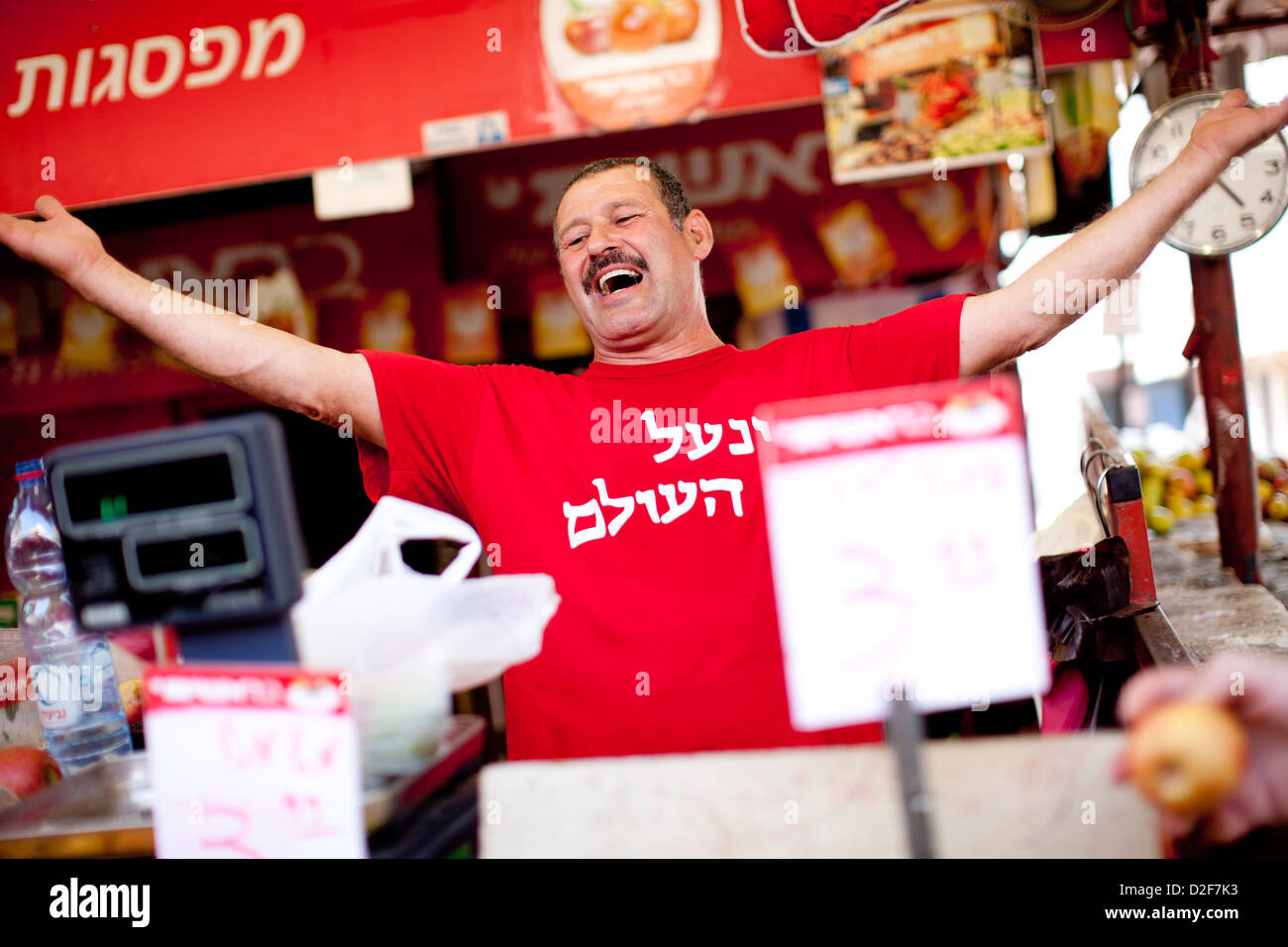 A market stall owner in Tel Aviv, Israel, sings to his customers as ...