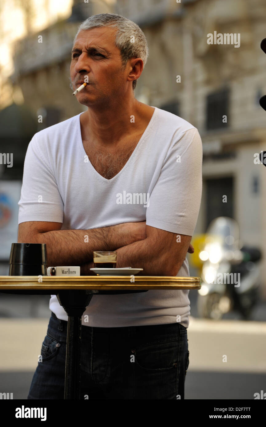 Man smoking whilst having coffee at an outdoor café in Paris Stock ...