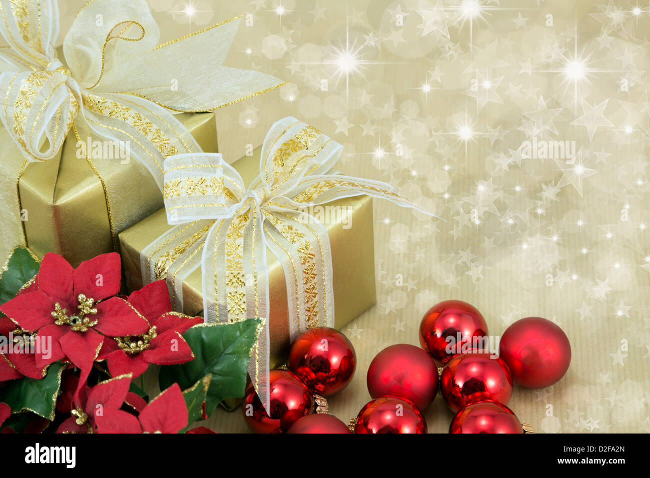 Beautifully wrapped gold presents with red baubles and flower ...