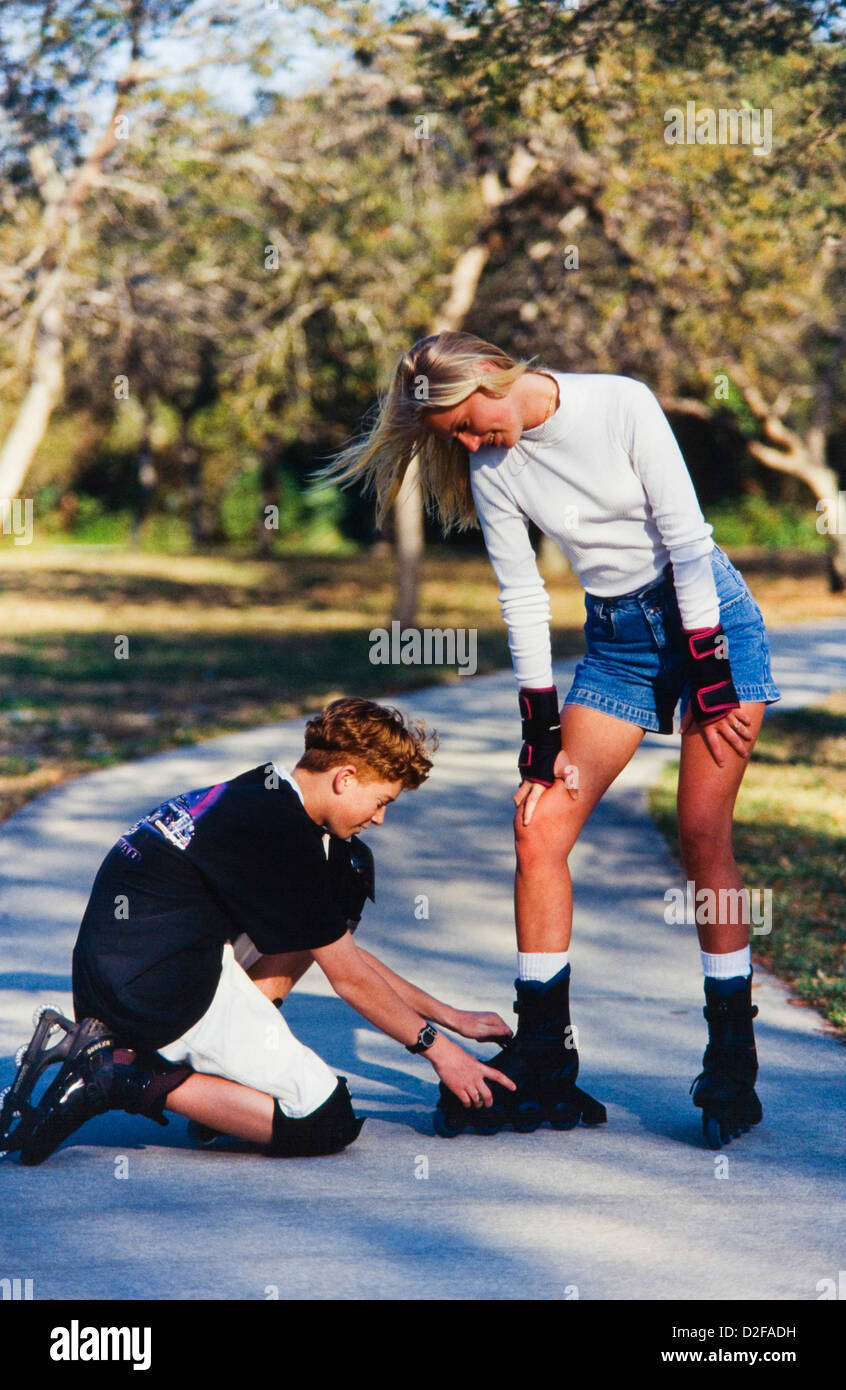 Teenagers rollerblading together, goofing off, teasing, playing Stock ...