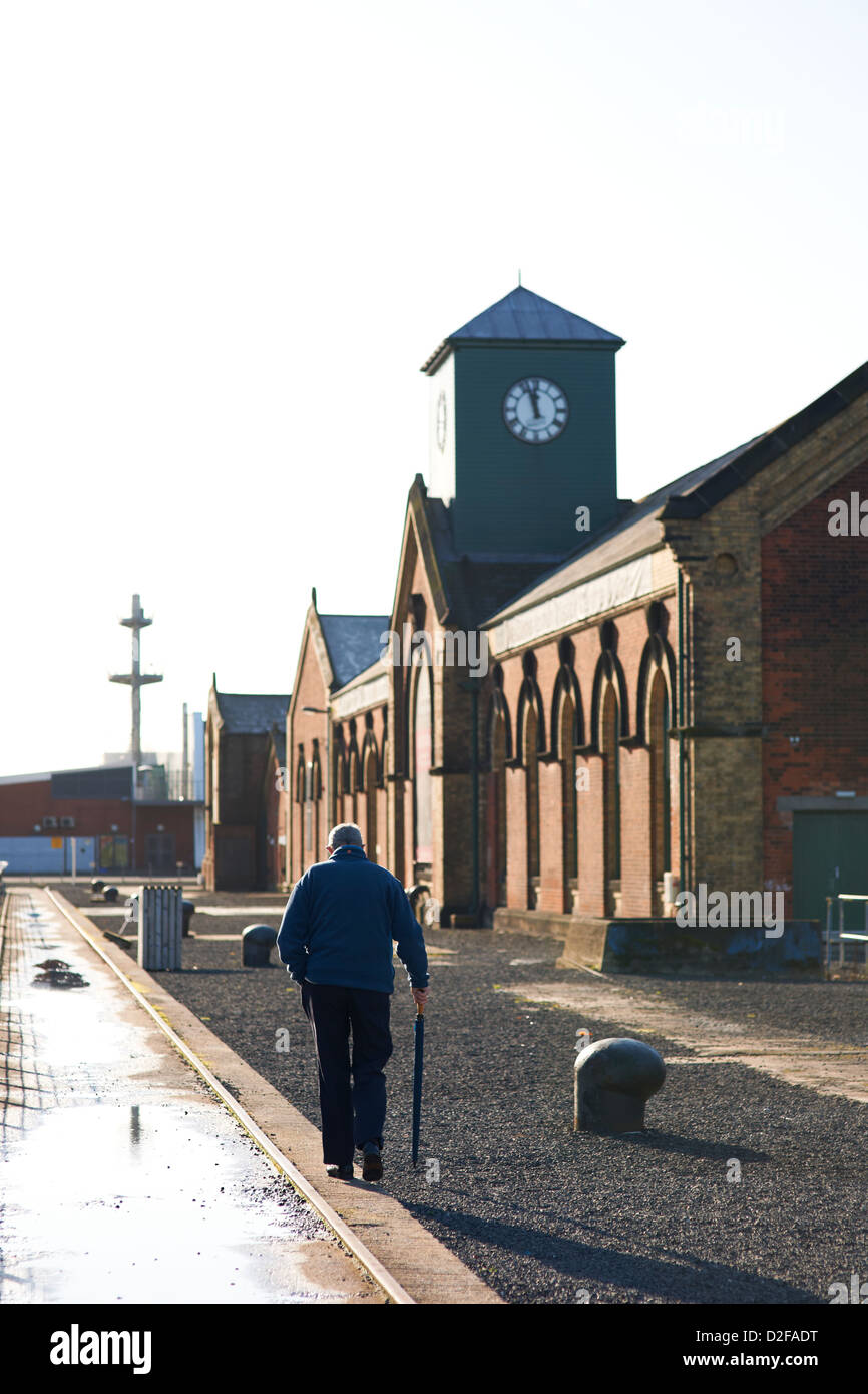 Elderly man walking towards the Thompson Dock Pump house which was used ...