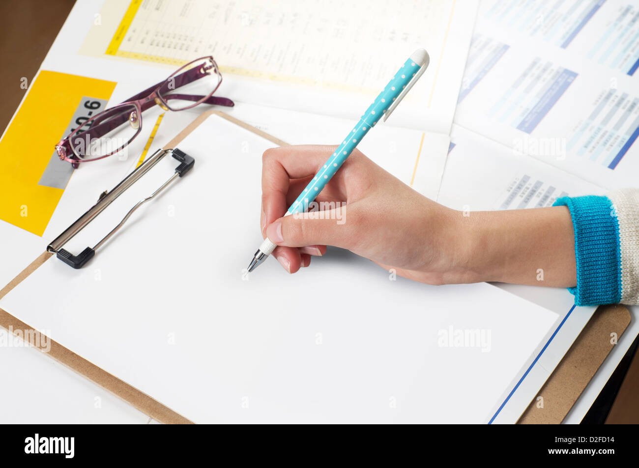 Woman writing on a folder Stock Photo - Alamy