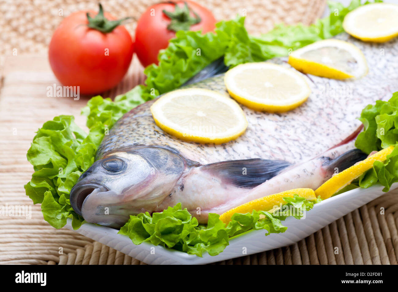 Fresh fish with sliced lemon and vegetables Stock Photo - Alamy