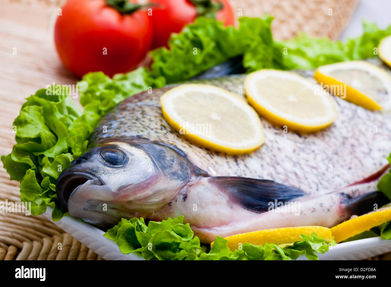Fresh fish with sliced lemon and vegetables Stock Photo - Alamy