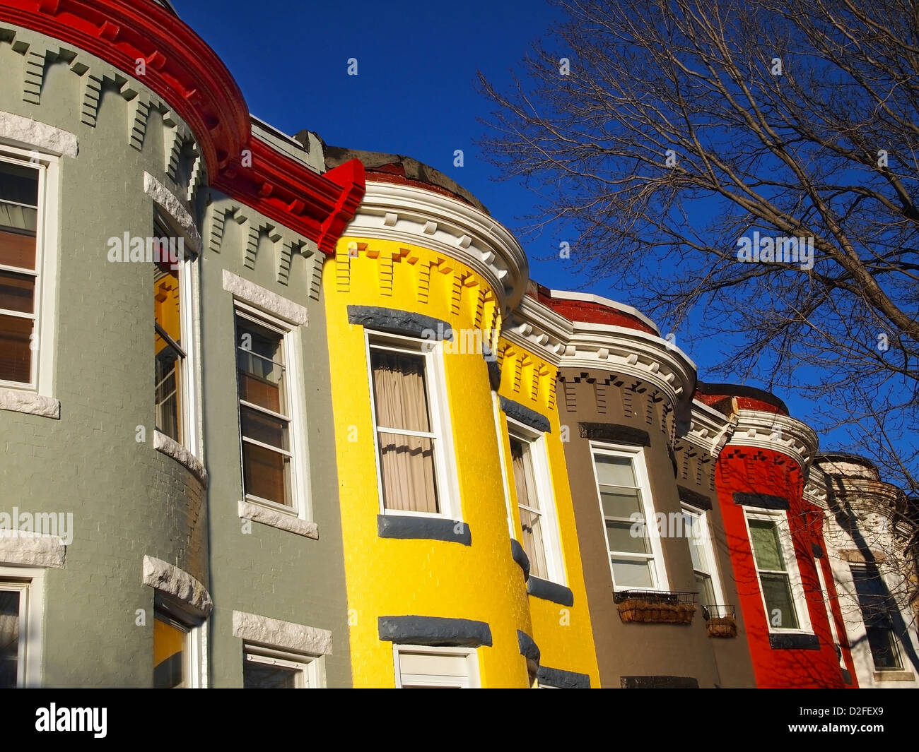 A row of brightly colored, vintage rowhomes in gray, red, yellow, white ...