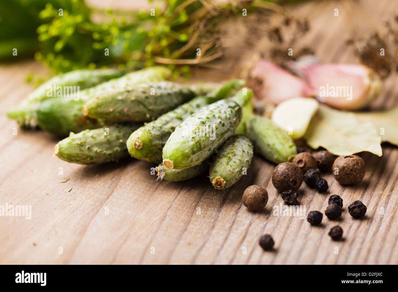 Preparation of small cucumber preserving on wooden table Stock Photo ...