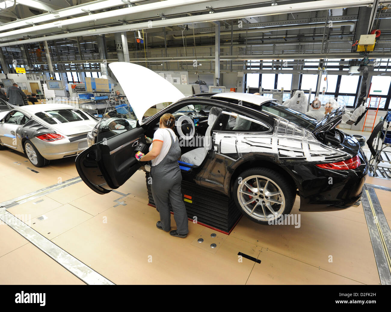 Employees of Porsche AG work at the assembly line of the model Porsche ...