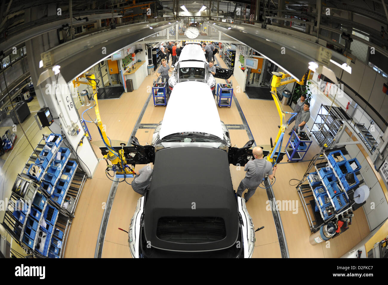 Employees of Porsche AG work at the assembly line of the model Porsche ...