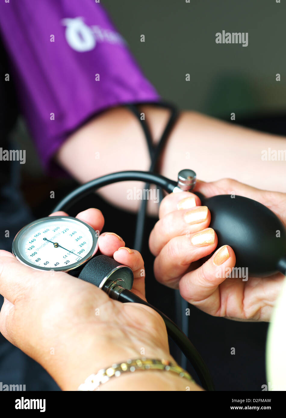 Female blood pressure being taken in UK GP Health Centre by female ...