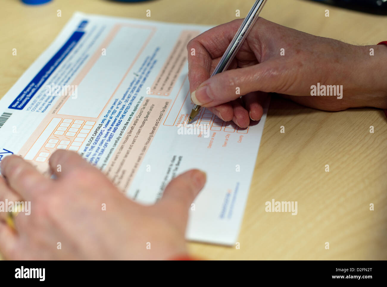Older white woman's hand filling in an official form, tcking boxes and ...