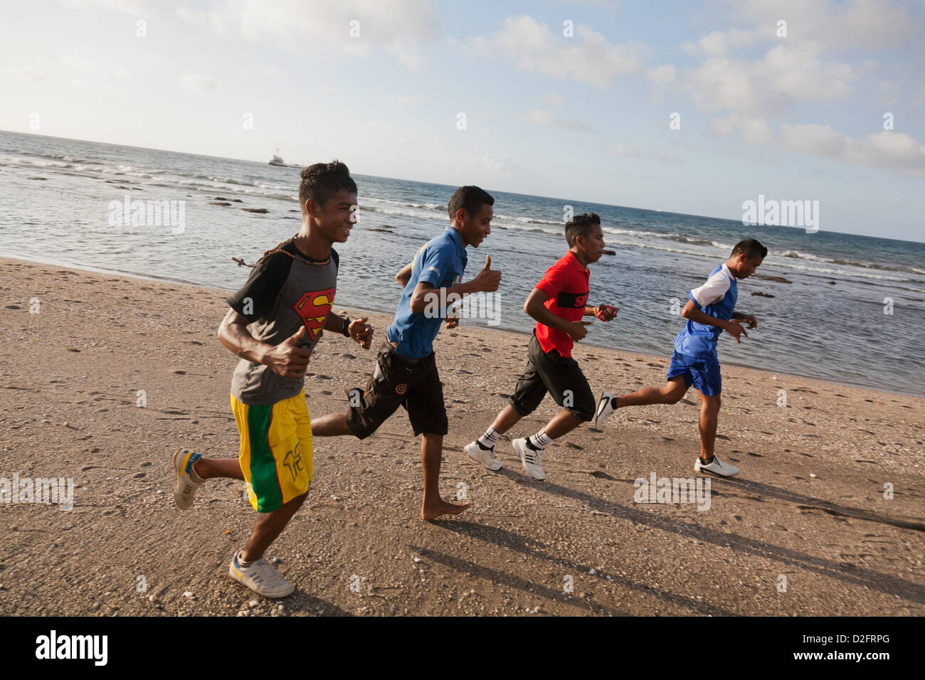 Young men running along the beach in Dili, Timor Leste Stock Photo - Alamy