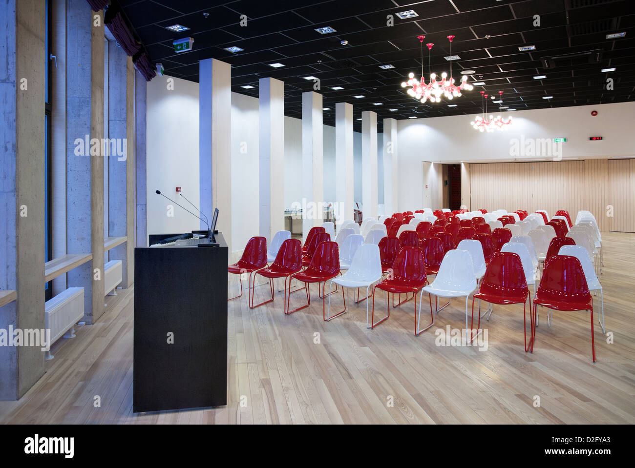 Modern large conference hall with lectern podium. Colorful chairs in ...
