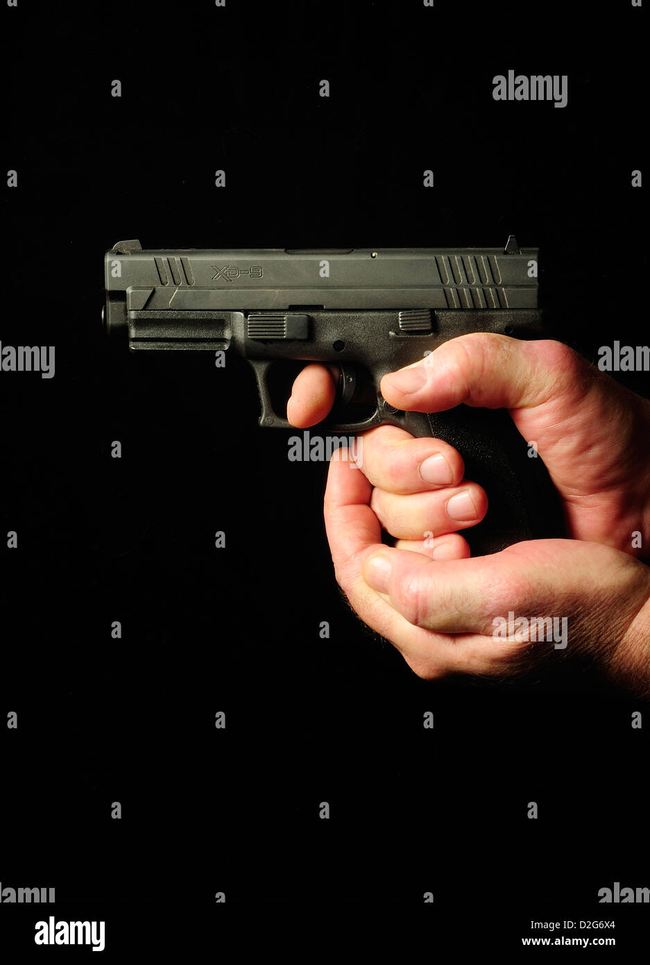 Shooters hand aiming 9mm Springfield Armory XD semi-automatic pistol ...