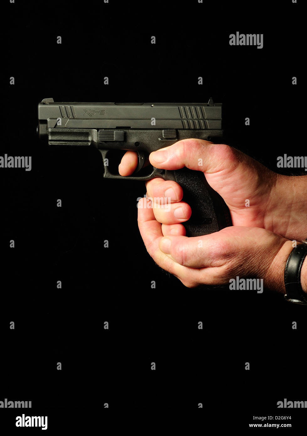 Shooters hand aiming 9mm Springfield Armory XD semi-automatic pistol ...