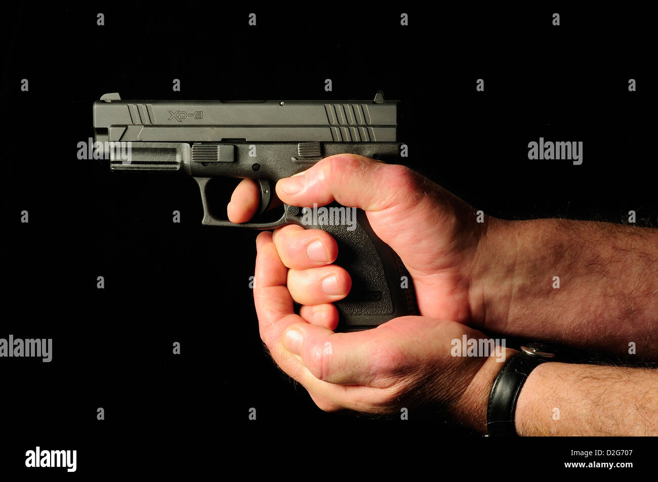 Shooters hand aiming 9mm Springfield Armory XD semi-automatic pistol ...