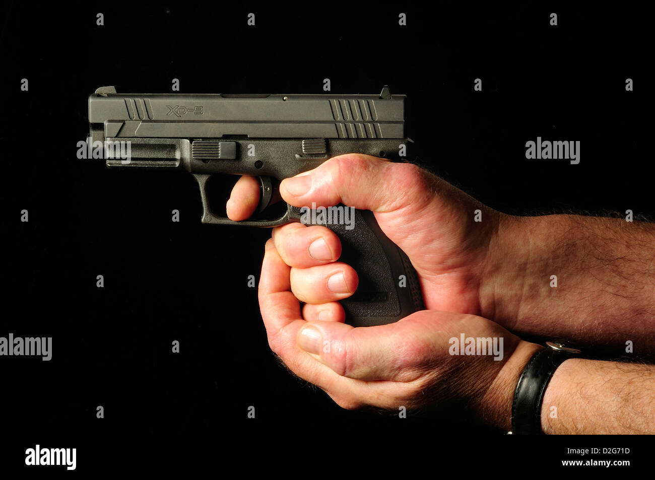 Shooters hand aiming 9mm Springfield Armory XD semi-automatic pistol ...