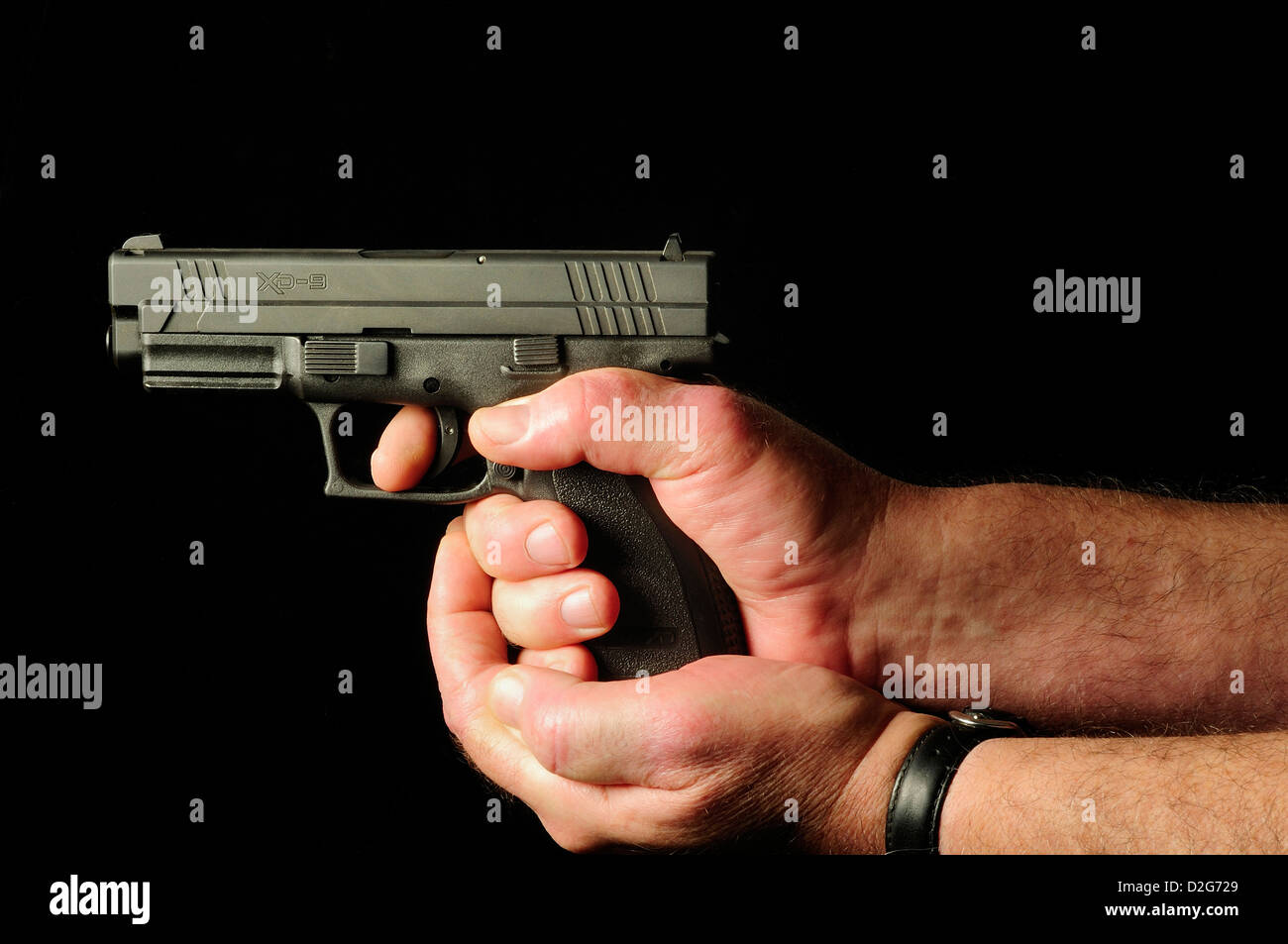 Shooters hand aiming 9mm Springfield Armory XD semi-automatic pistol ...