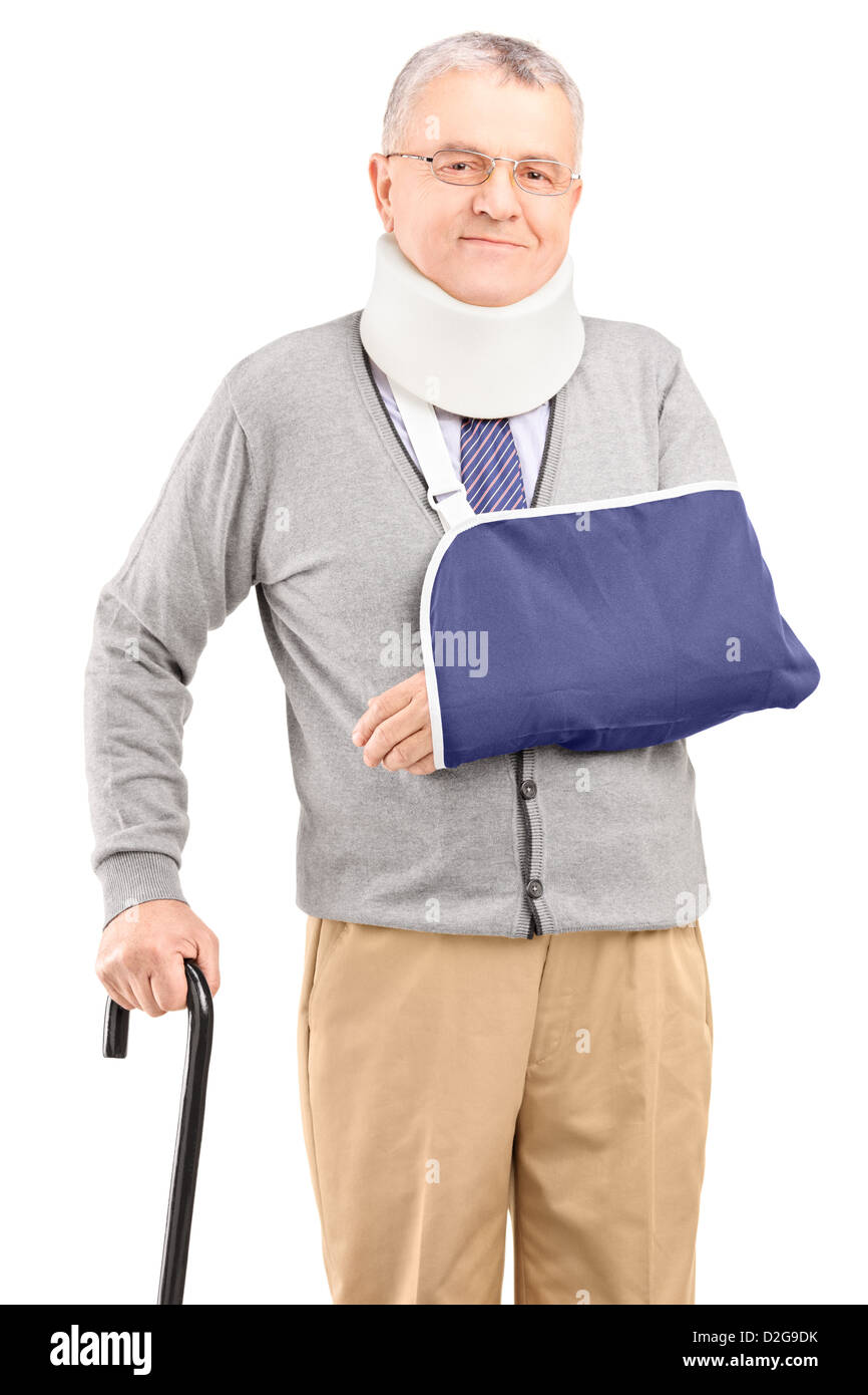 Injured mature man with broken arm posing with a cane isolated on white ...