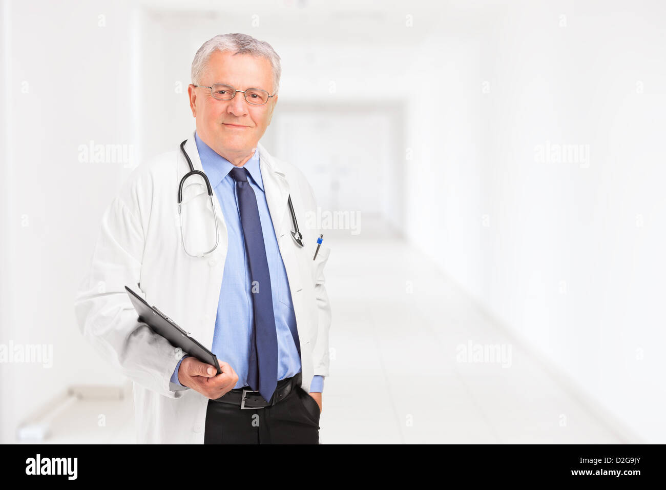 Male doctor holding a clipboard and standing in a hospital hall Stock ...