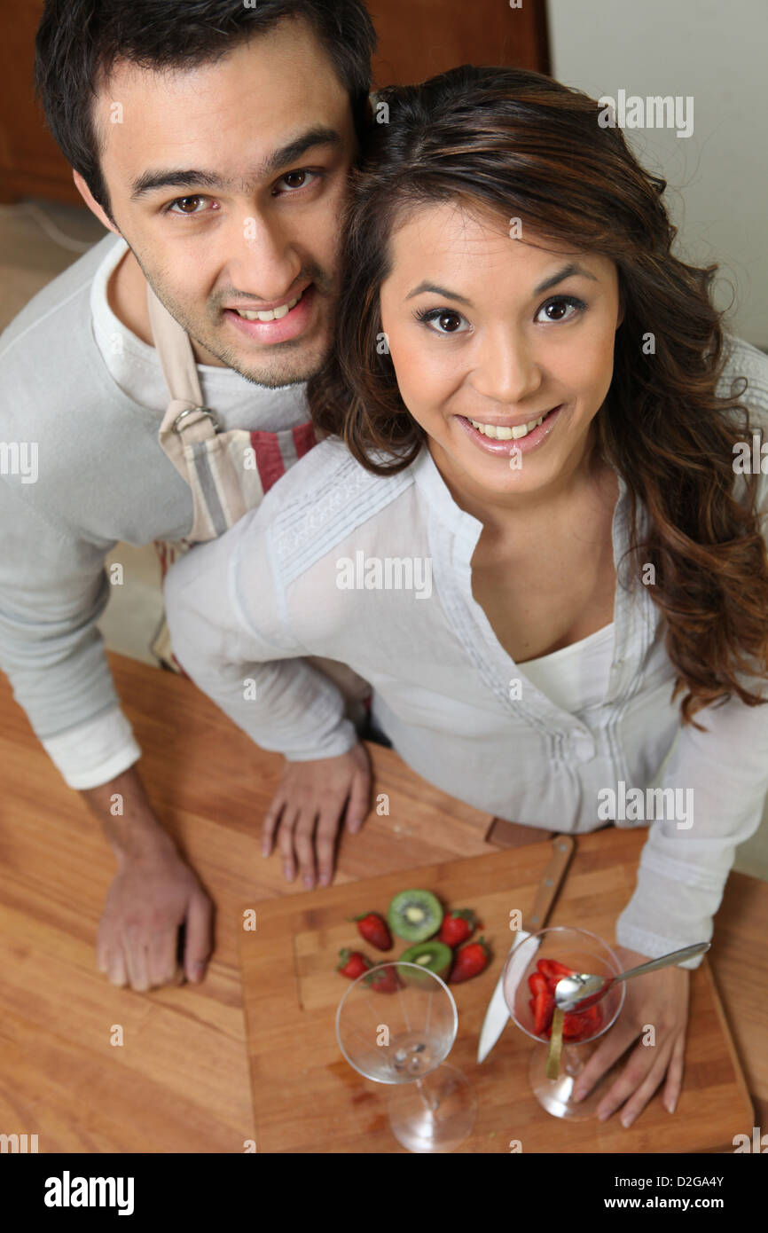 high angle shot of couple all smiles slicing fruits Stock Photo - Alamy