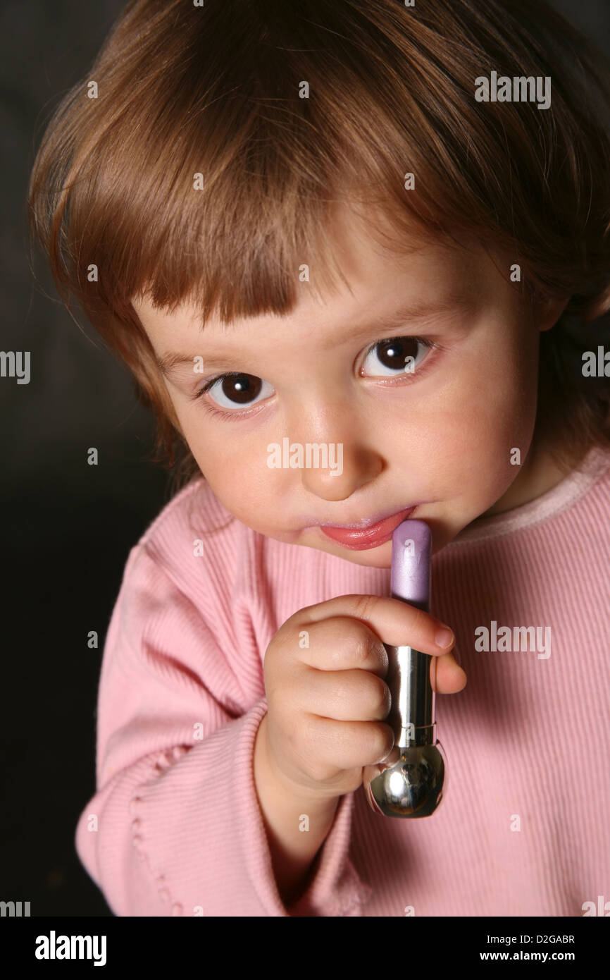 The little girl with lipstick in hand Stock Photo - Alamy