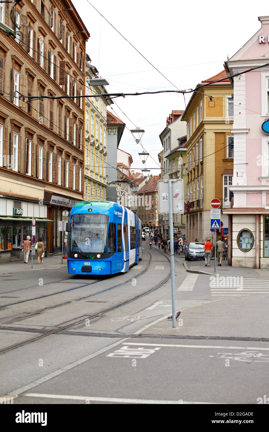A blue tram navigates the charming streets of Graz, Austria, blending ...