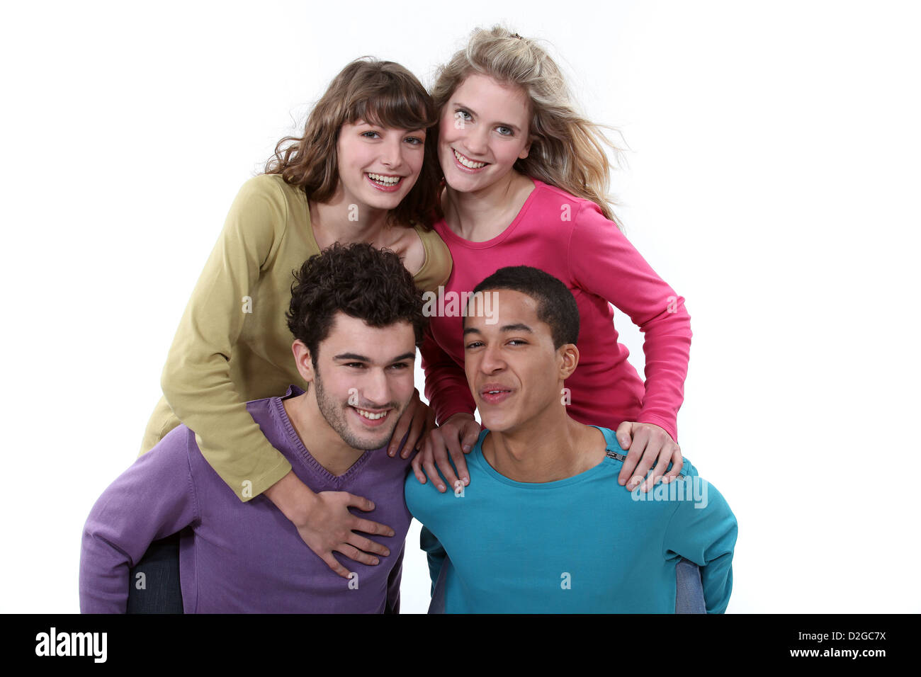 Two couples racing a piggy back race Stock Photo - Alamy