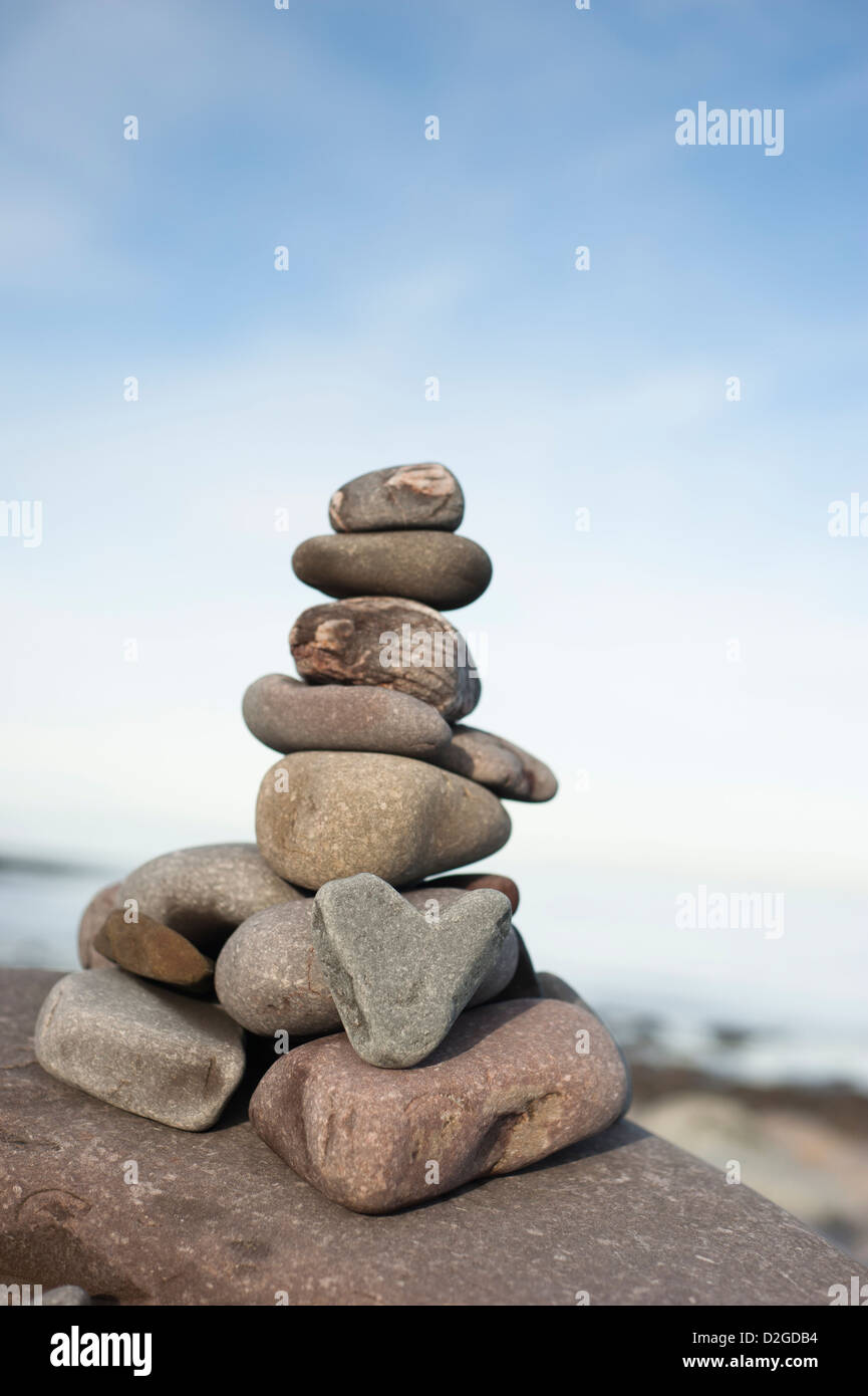 Heart-shaped stone with a stack of stones on the beach at Porlock Weir ...