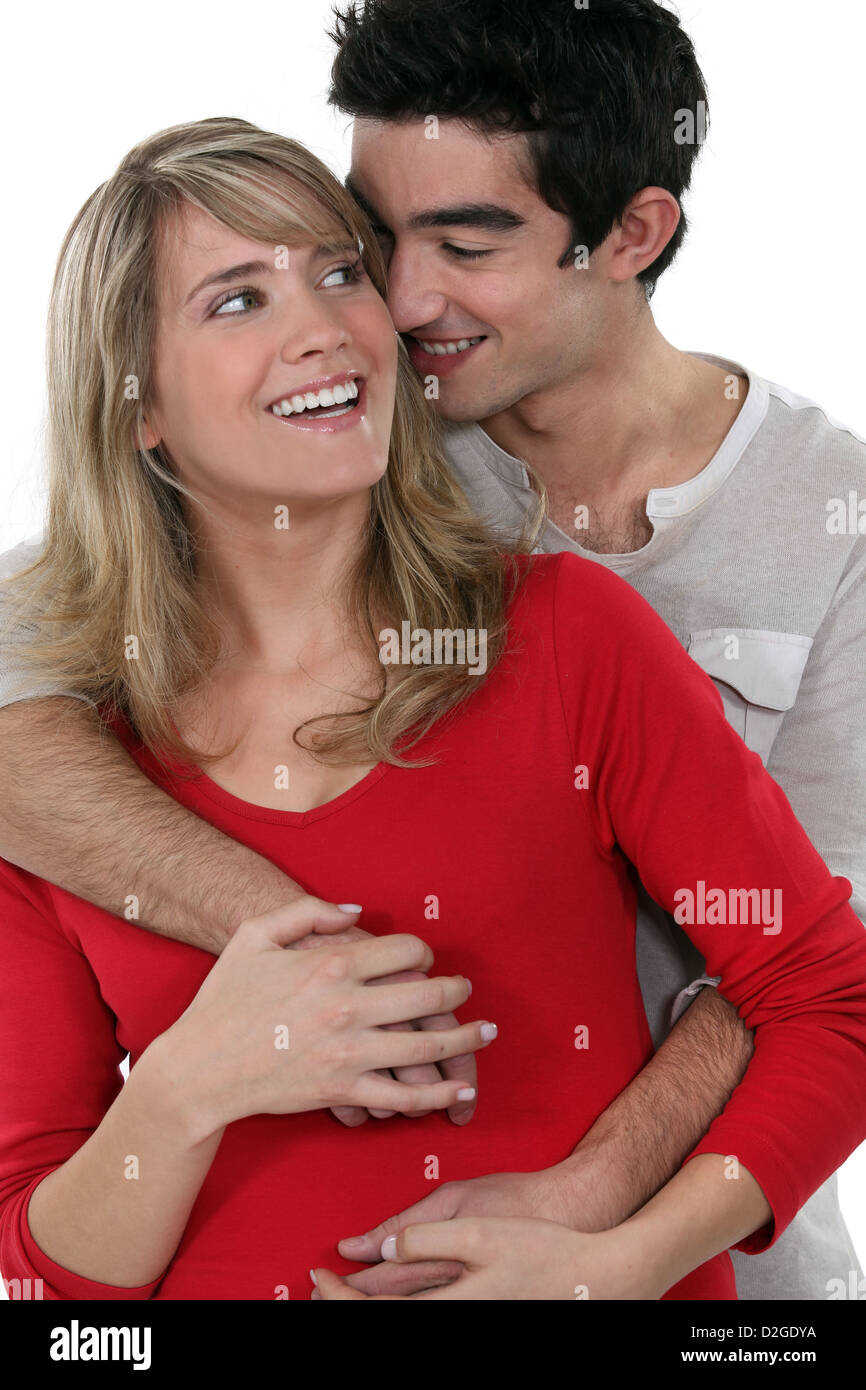 young happy couple embracing against studio background Stock Photo - Alamy