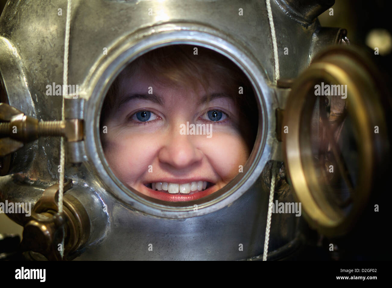 Bright smiling face of woman wearing a vintage Mark V diving helmet ...