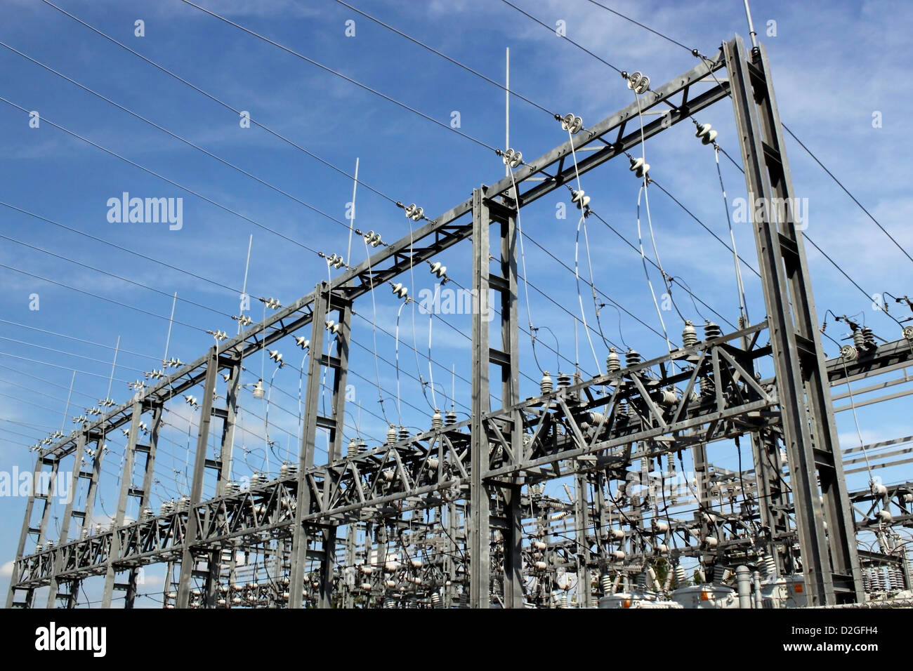 A large power station construction of steel and cable against a blue ...