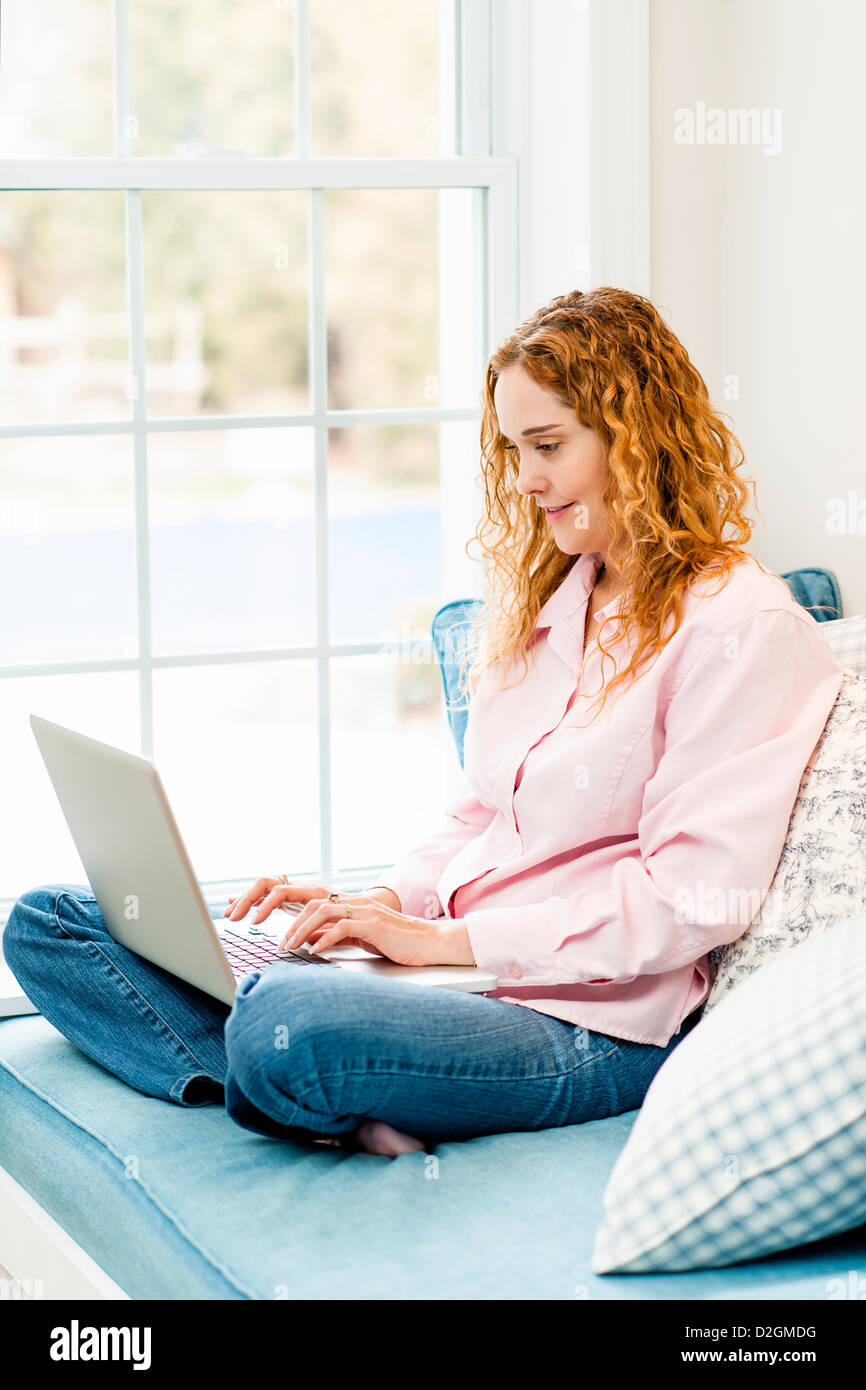 Caucasian woman using laptop computer sitting on couch at home Stock ...