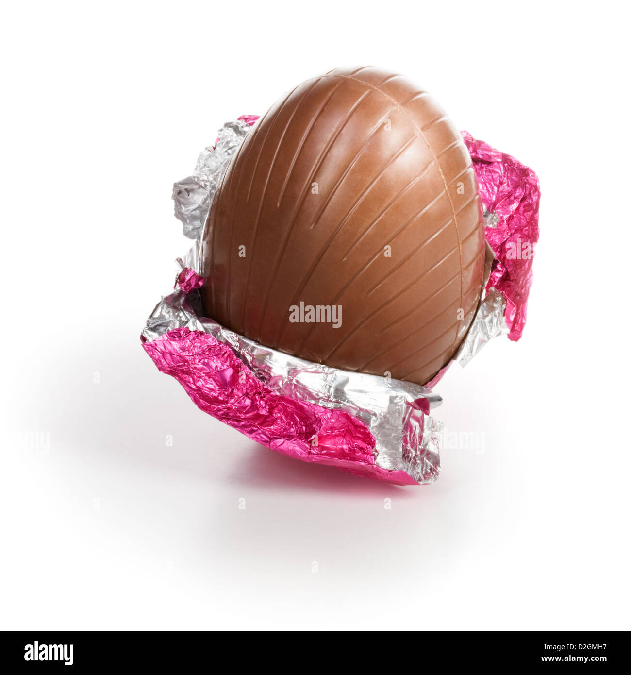 Chocolate candy Easter egg wrapped in pink foil on white background ...