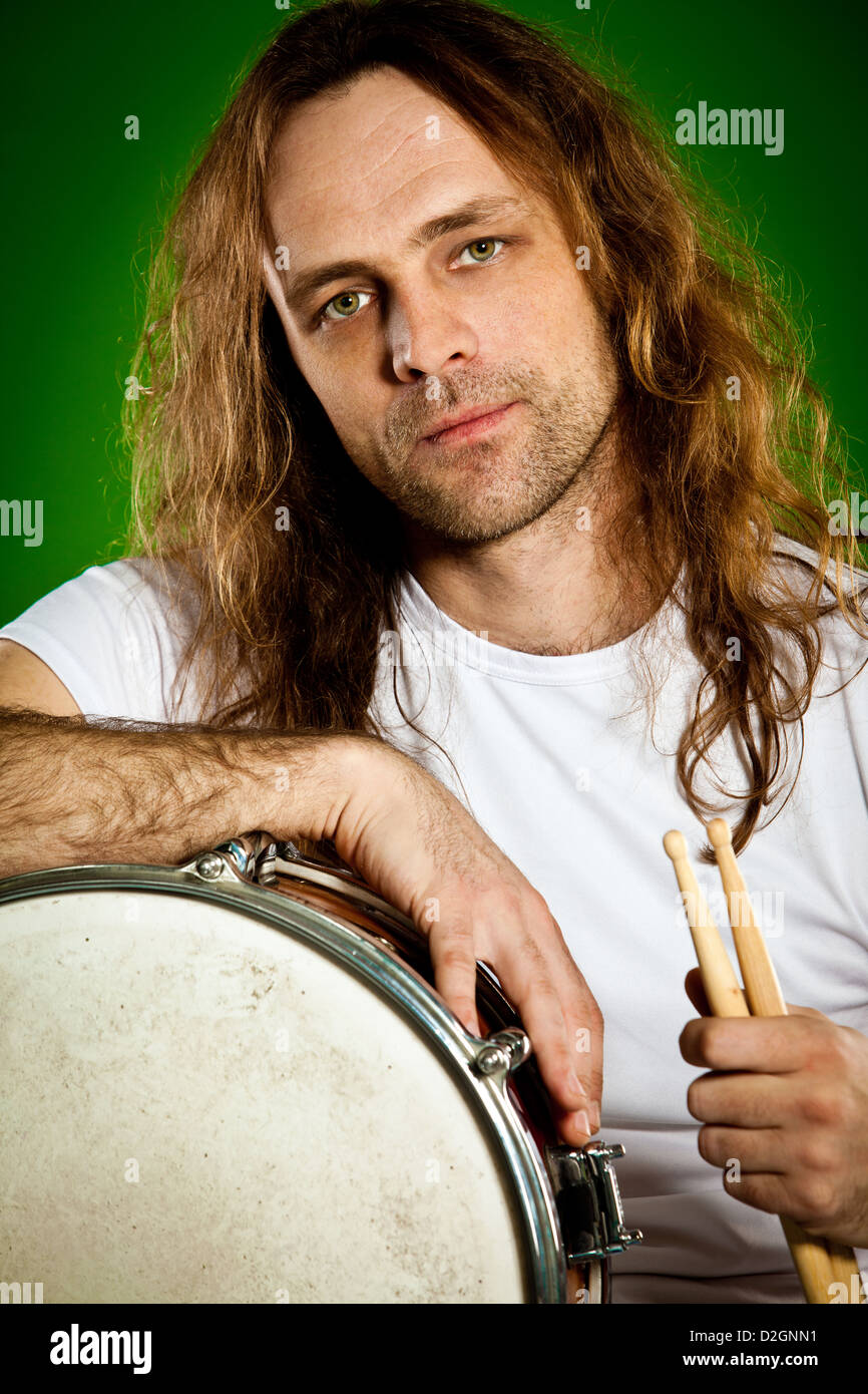 Portrait of the drummer man on a green background Stock Photo - Alamy