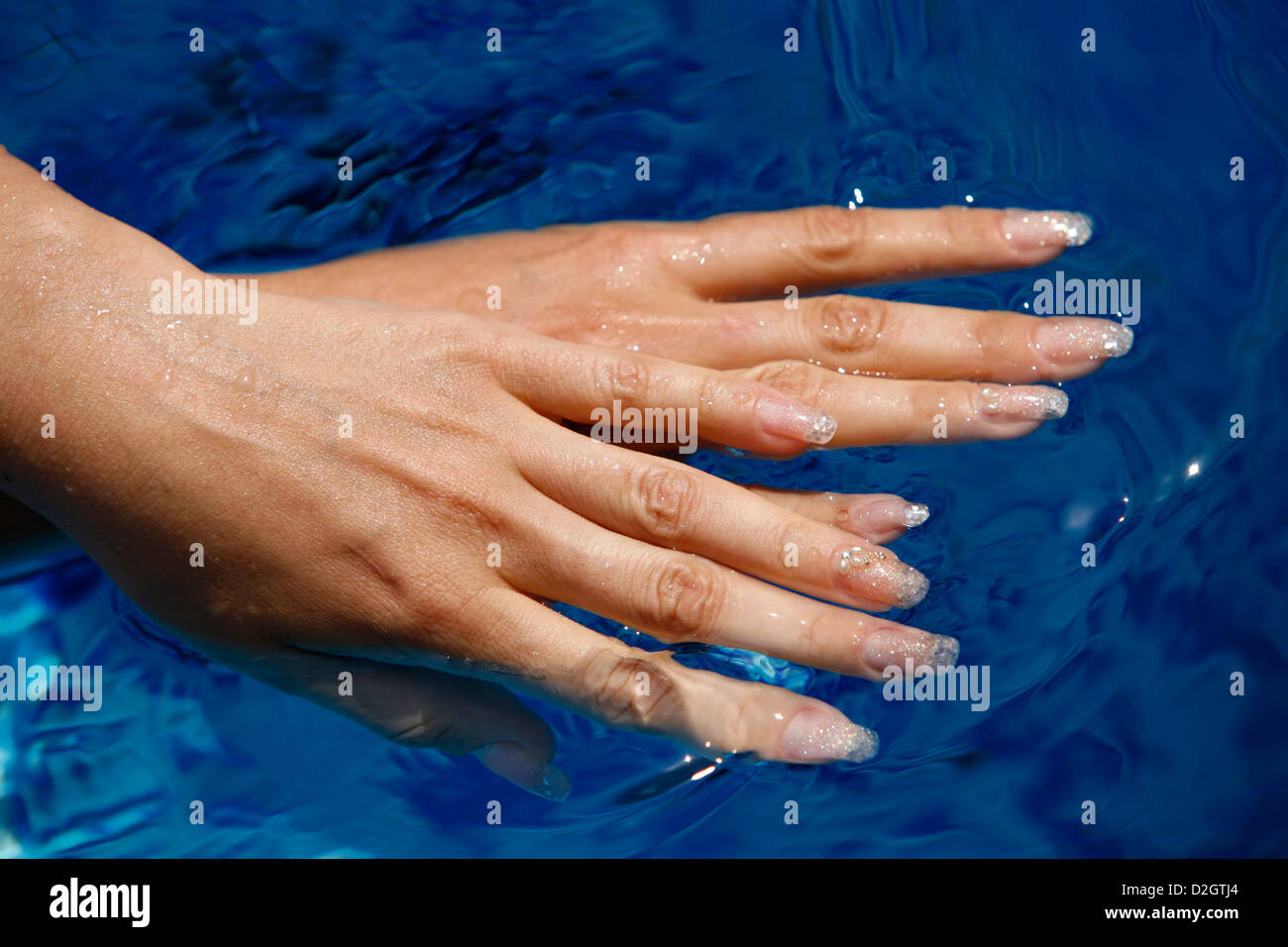 Beautiful female hands in blue water Stock Photo - Alamy