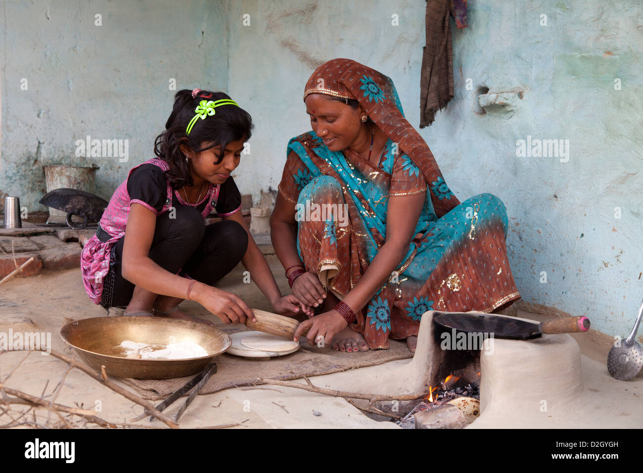 Mother and daughter preparing traditional India Roti bread. Model ...