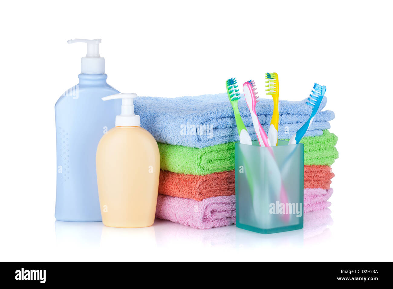 Four colorful toothbrushes, cosmetics bottles and towels. Isolated on ...