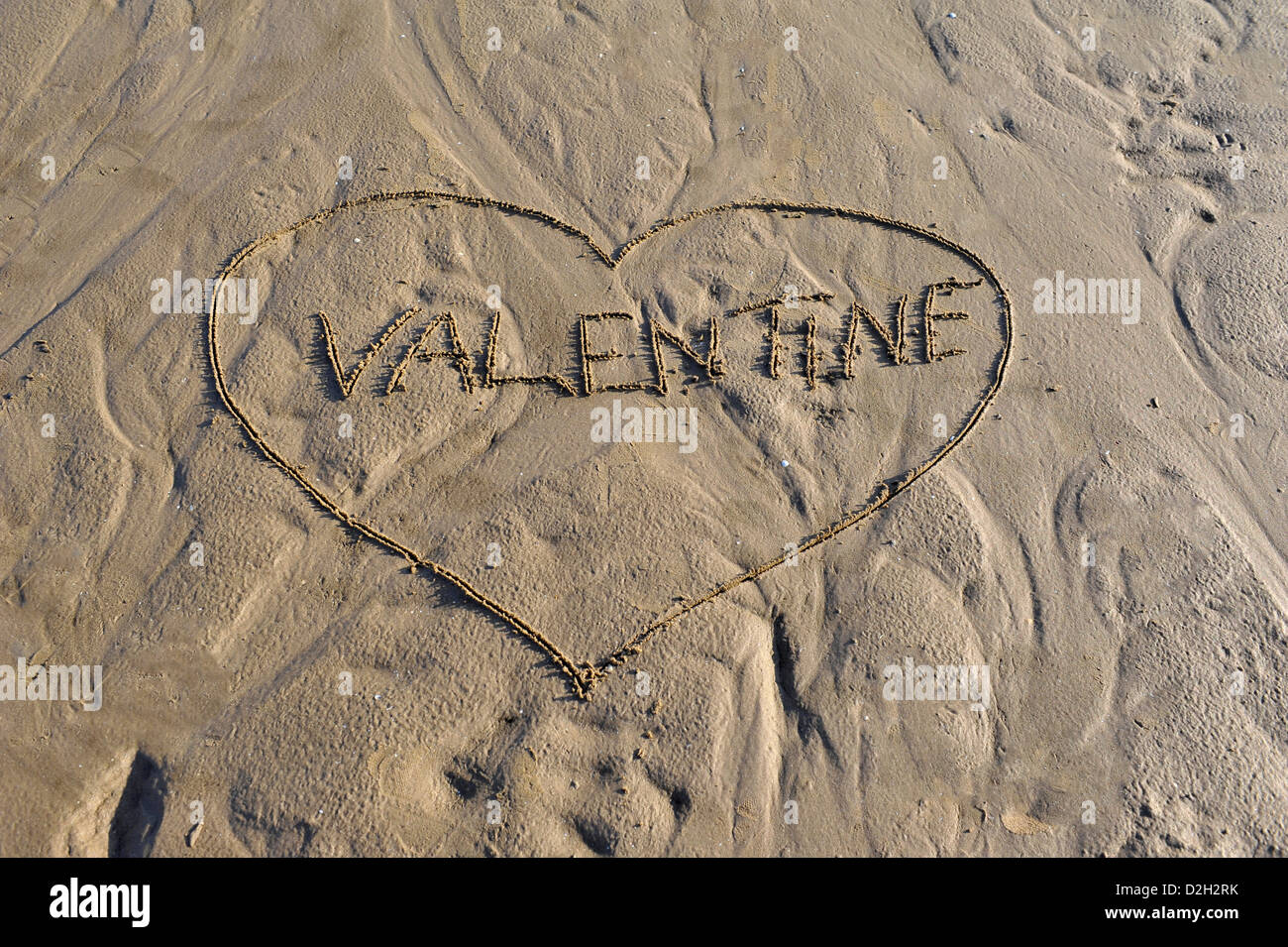Word Valentine written in sand Stock Photo - Alamy