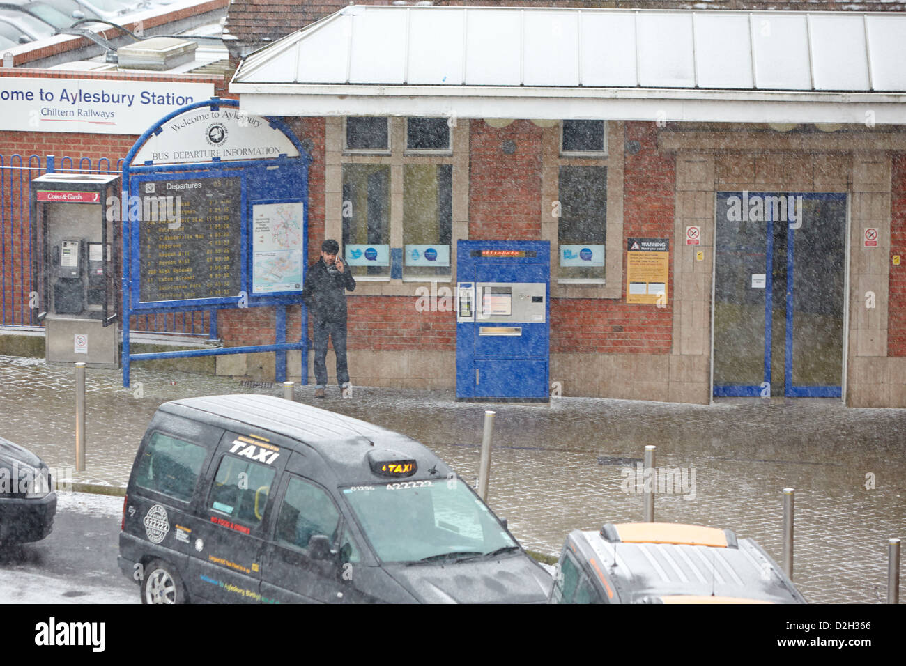A commuter waits to board a train at Aylesbury Train Station in snowy ...