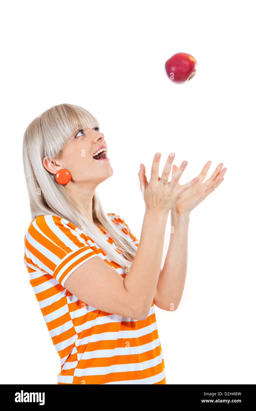 Beautiful blond girl throwing an apple isolated on white background ...